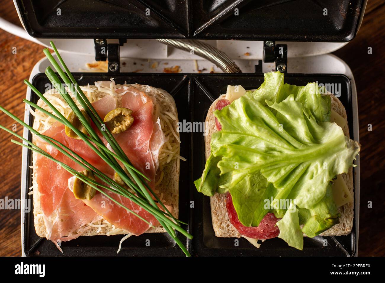 Making sandwiches from ham, vegetables and cheese in a sandwich maker ...