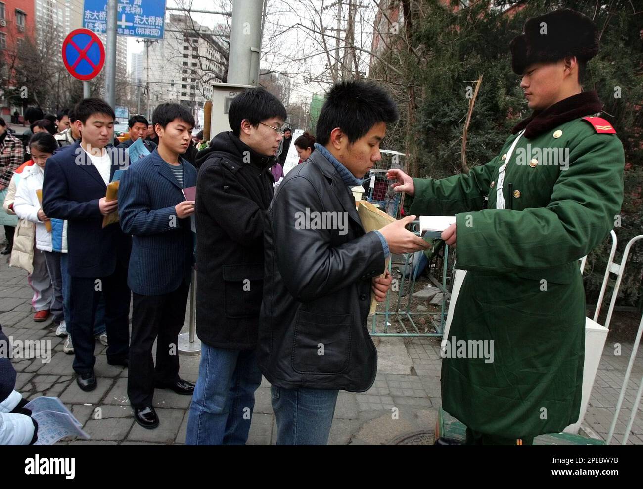 A Chinese paramilitary police guard checks the documents of visa ...