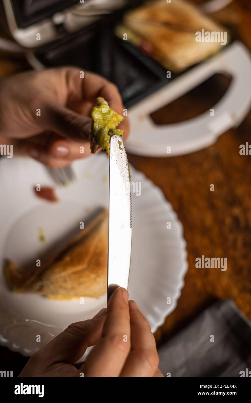 unrecognizable man eats toast with guacamole. Breakfast time. The man's ...
