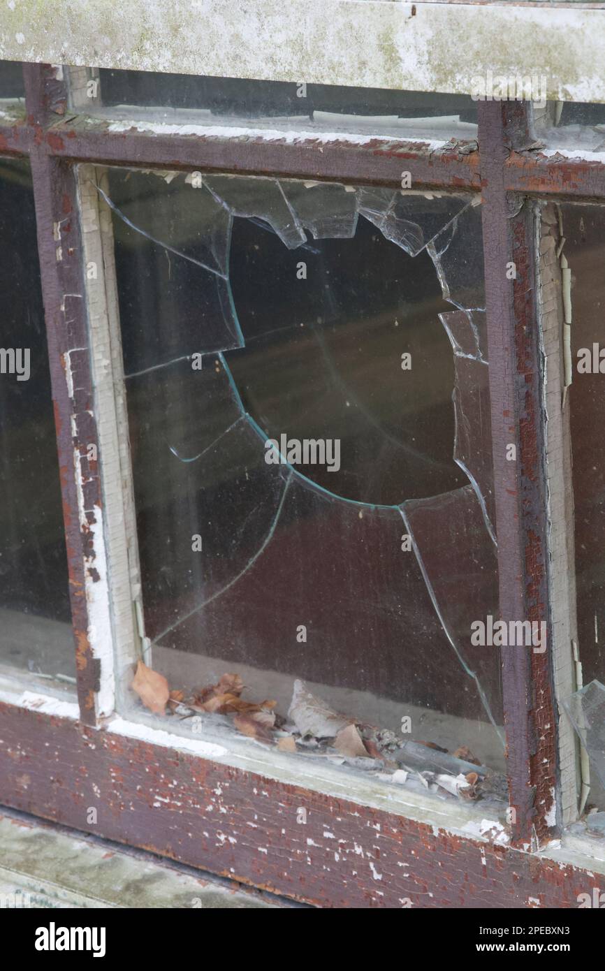 Broken window with fractured glass. Dirty, brown window frame with abandoned building Stock ...
