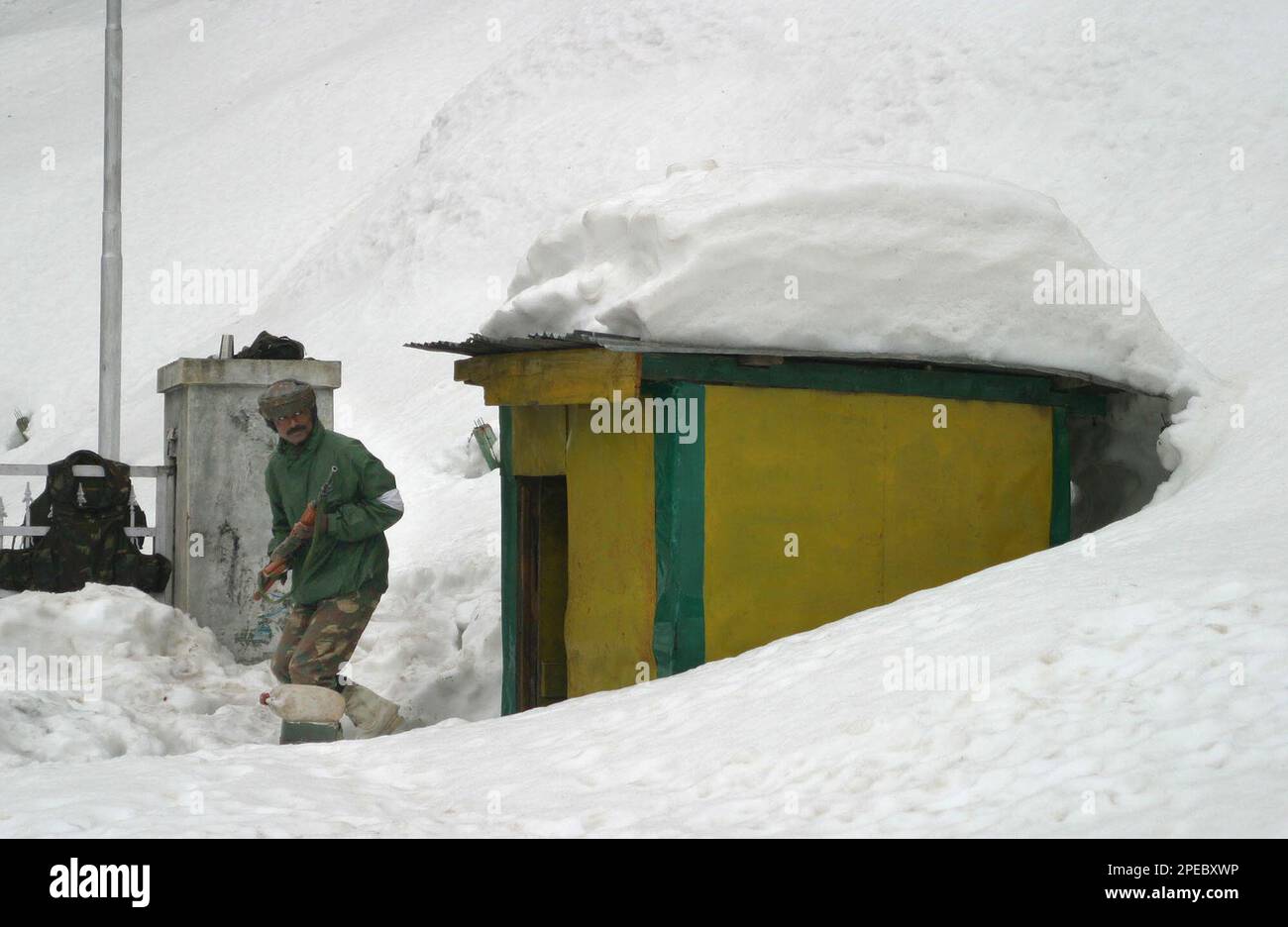 An Indian Army soldier keeps vigil outside his snow-covered bunker near ...