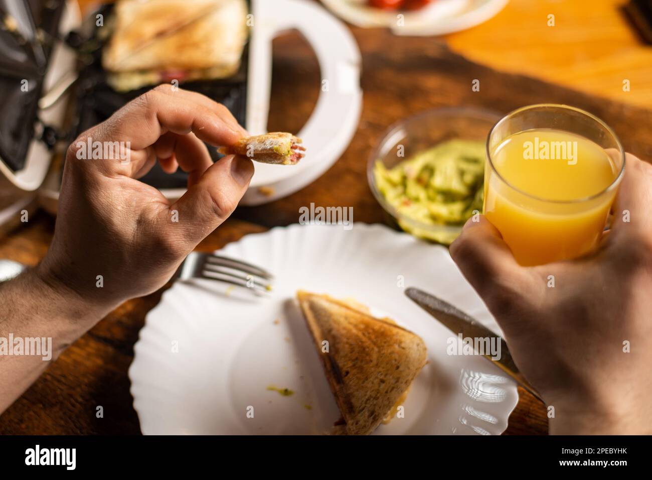 Unrecognizable man eats toast on a plate. Breakfast time. The man's ...