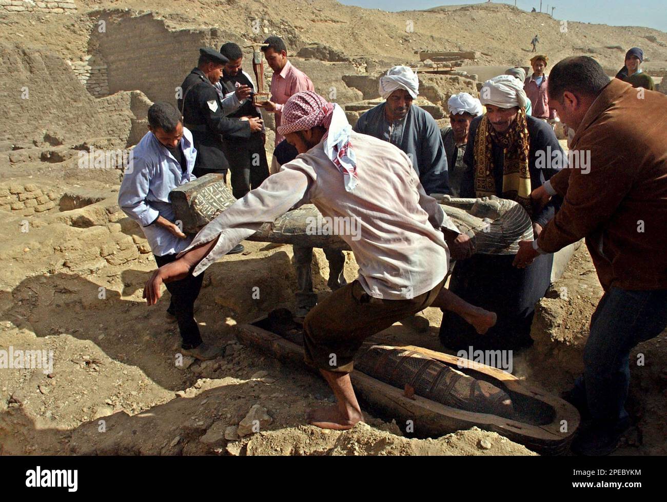 Egyptian workers open an ancient wooden coffin, shaped like a human ...