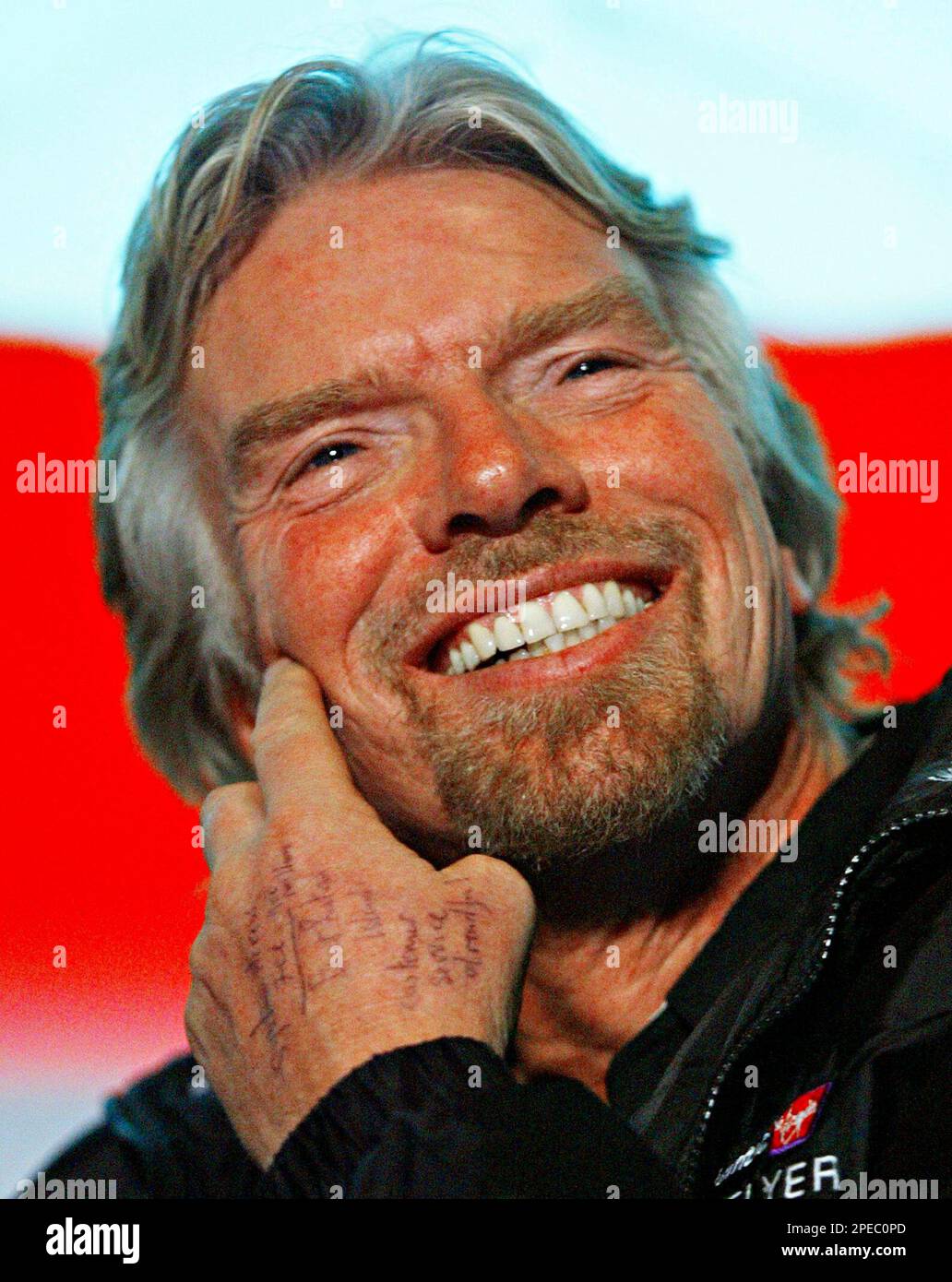 Richard Branson smiles as he listens to a question during the ...