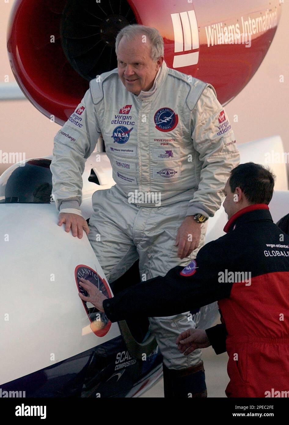 Pilot Steve Fossett is helped into the GlobalFlyer at the Salina ...