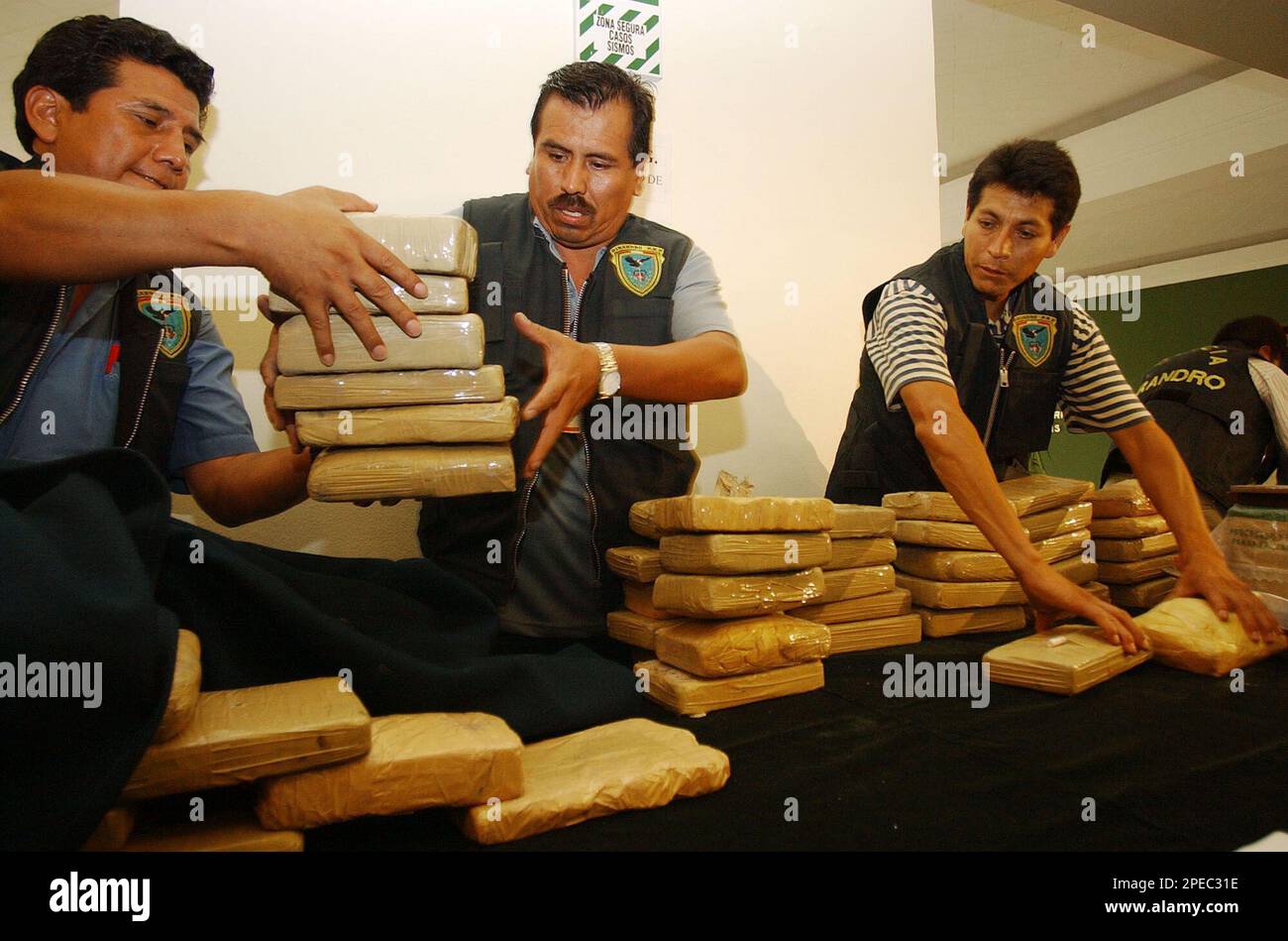 Peruvian anti-narcotics officers count packages of cocaine during a ...