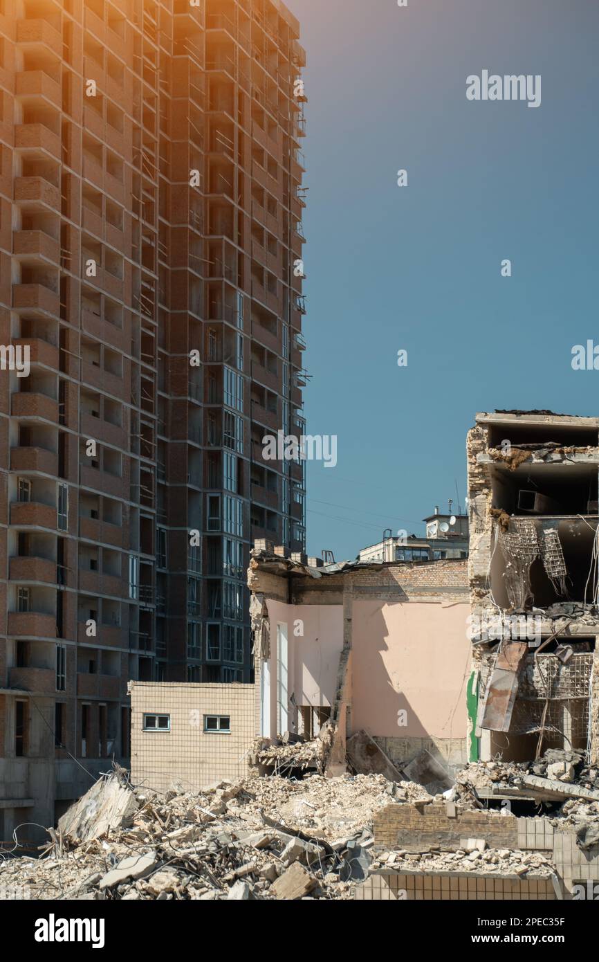 demolition of old building near new construction of modern skyscraper ...
