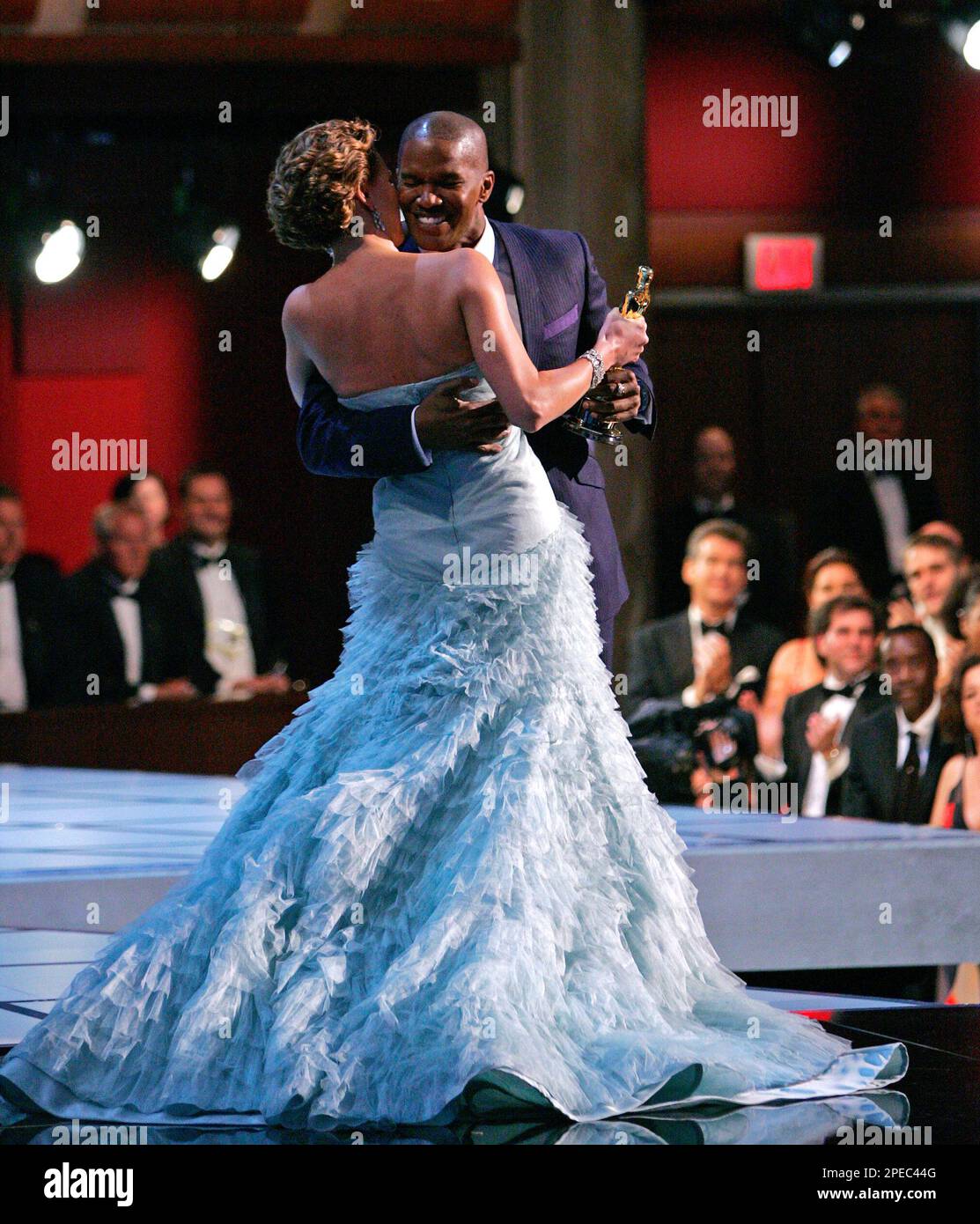 Actor Jaimie Foxx hugs actress Charlize Theron after winning the Oscar ...