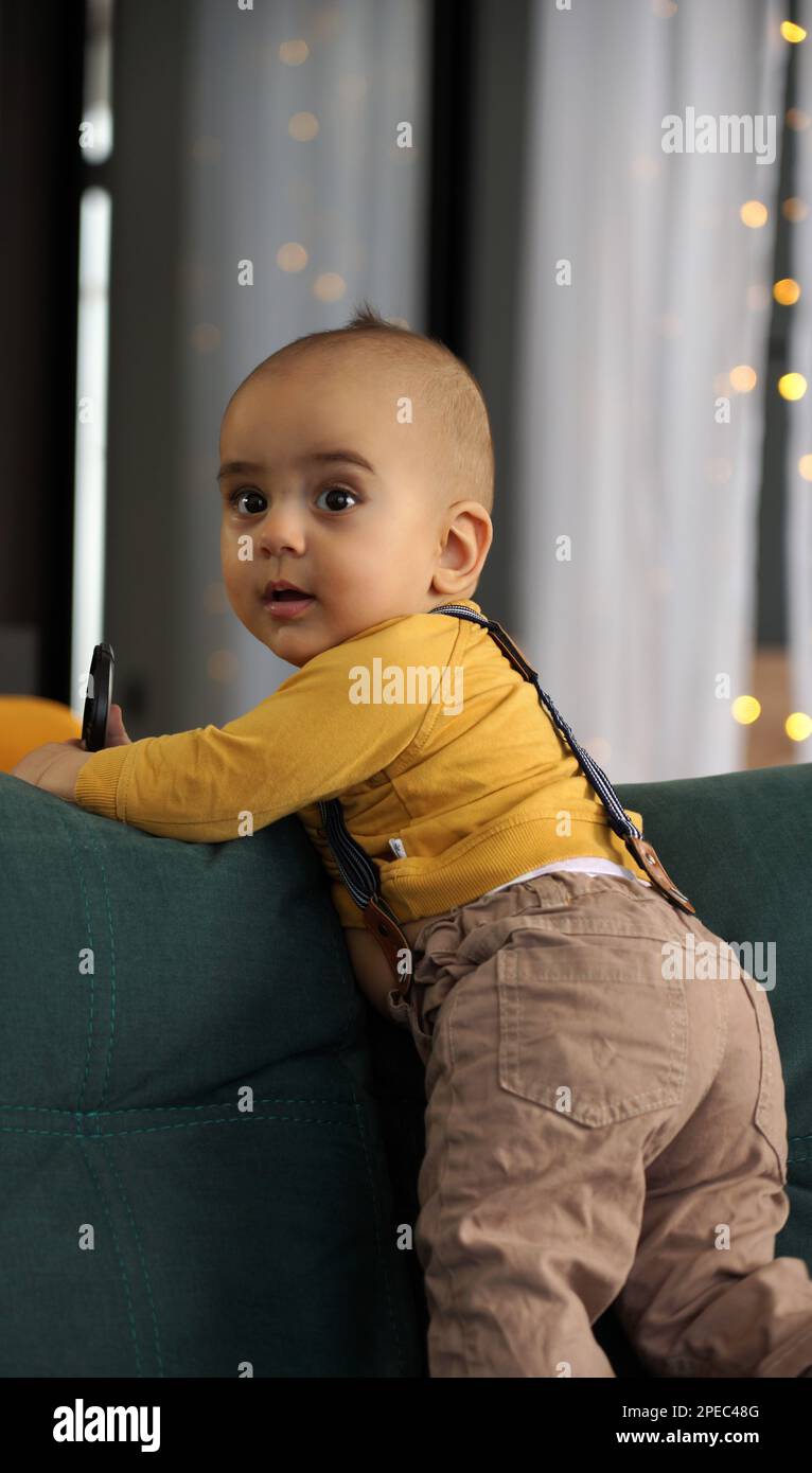 Adorable kid standing on sofa Stock Photo - Alamy