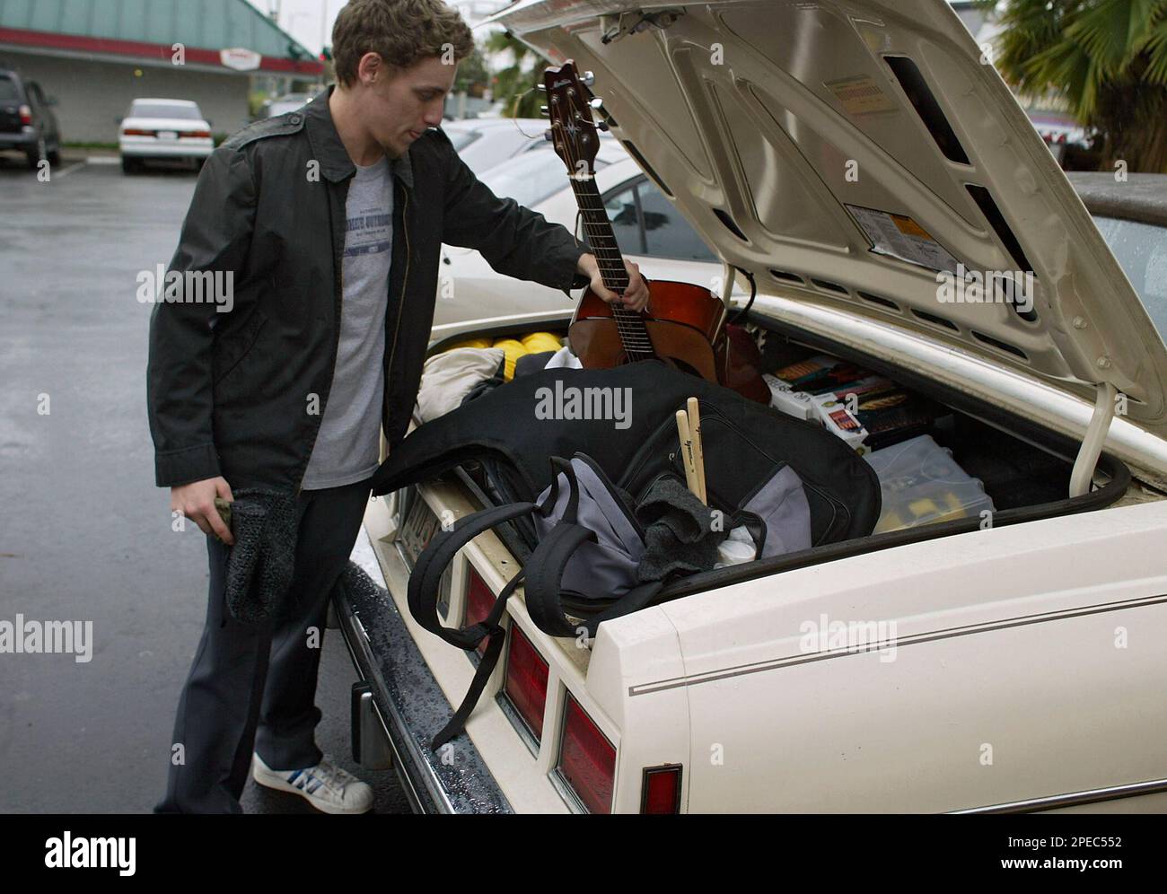 Andrew Stone, a teenage guitarist packs his guitar on the trunk of his ...