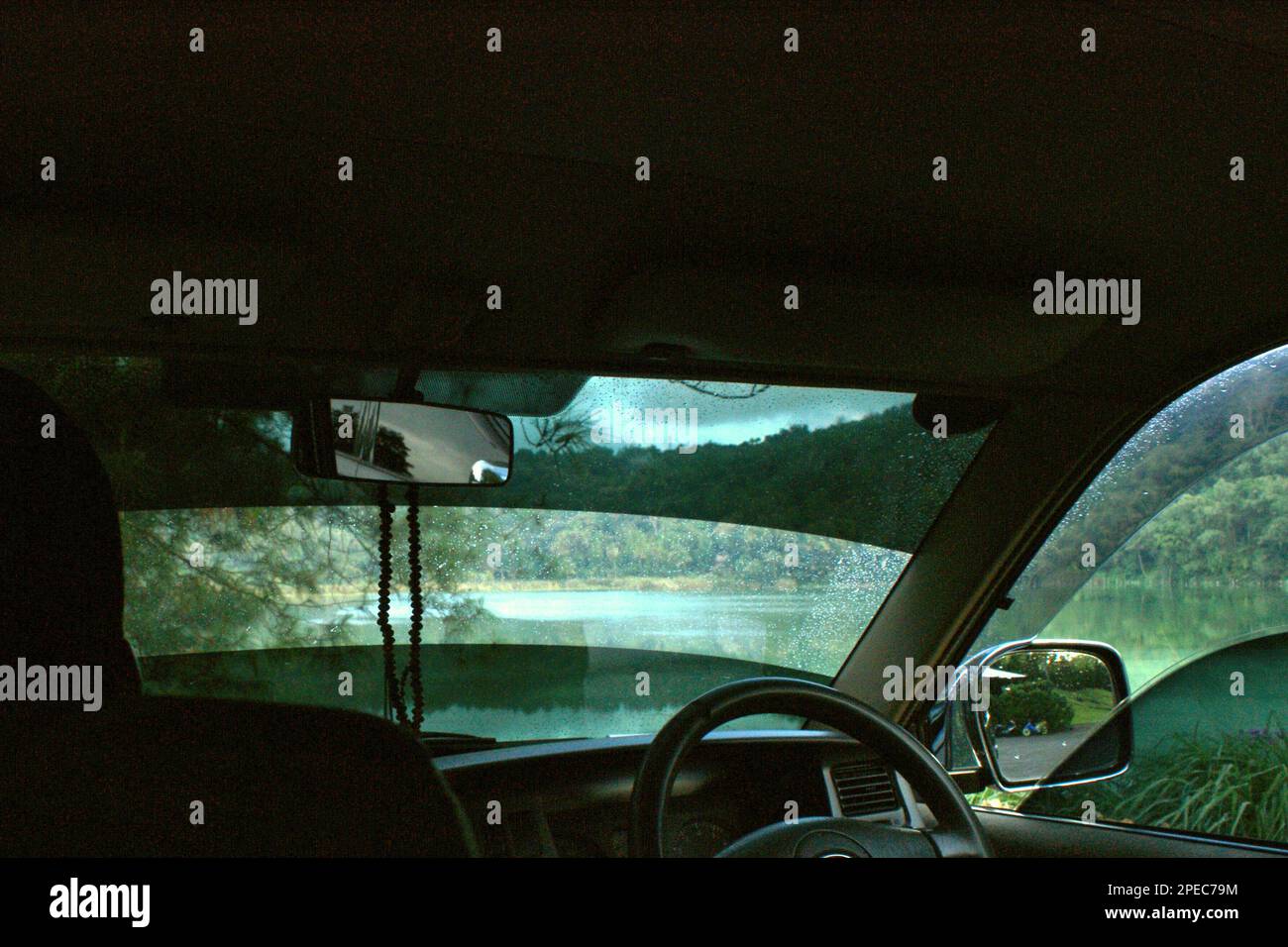 A scenery of Lake Linow, a volcanic lake, is seen from inside a car in ...