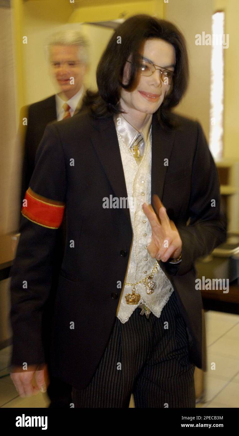 Michael Jackson gives a peace sign as he passes through the metal ...