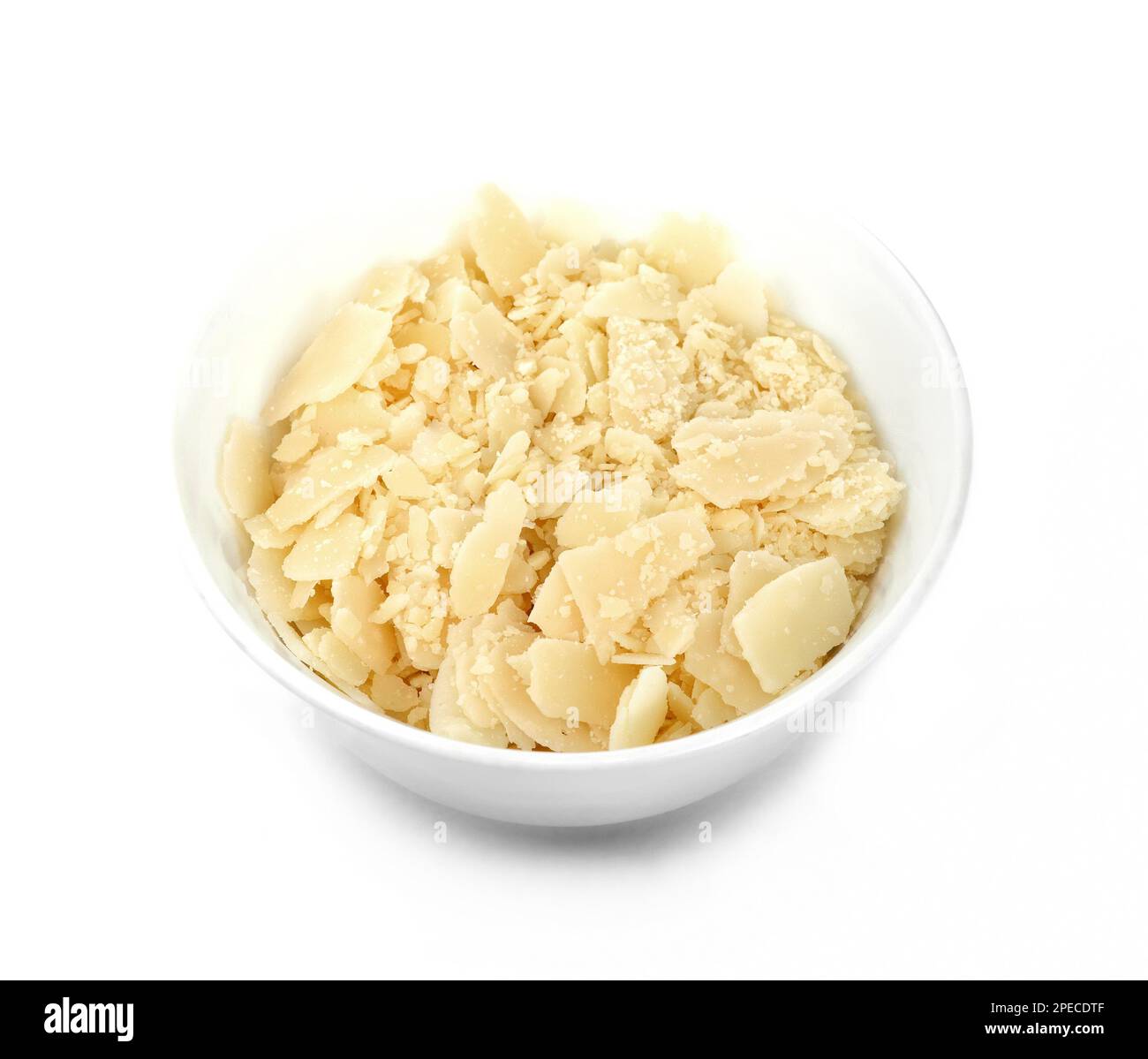Parmesan cheese flakes in a bowl isolated on white background. Pile of ...