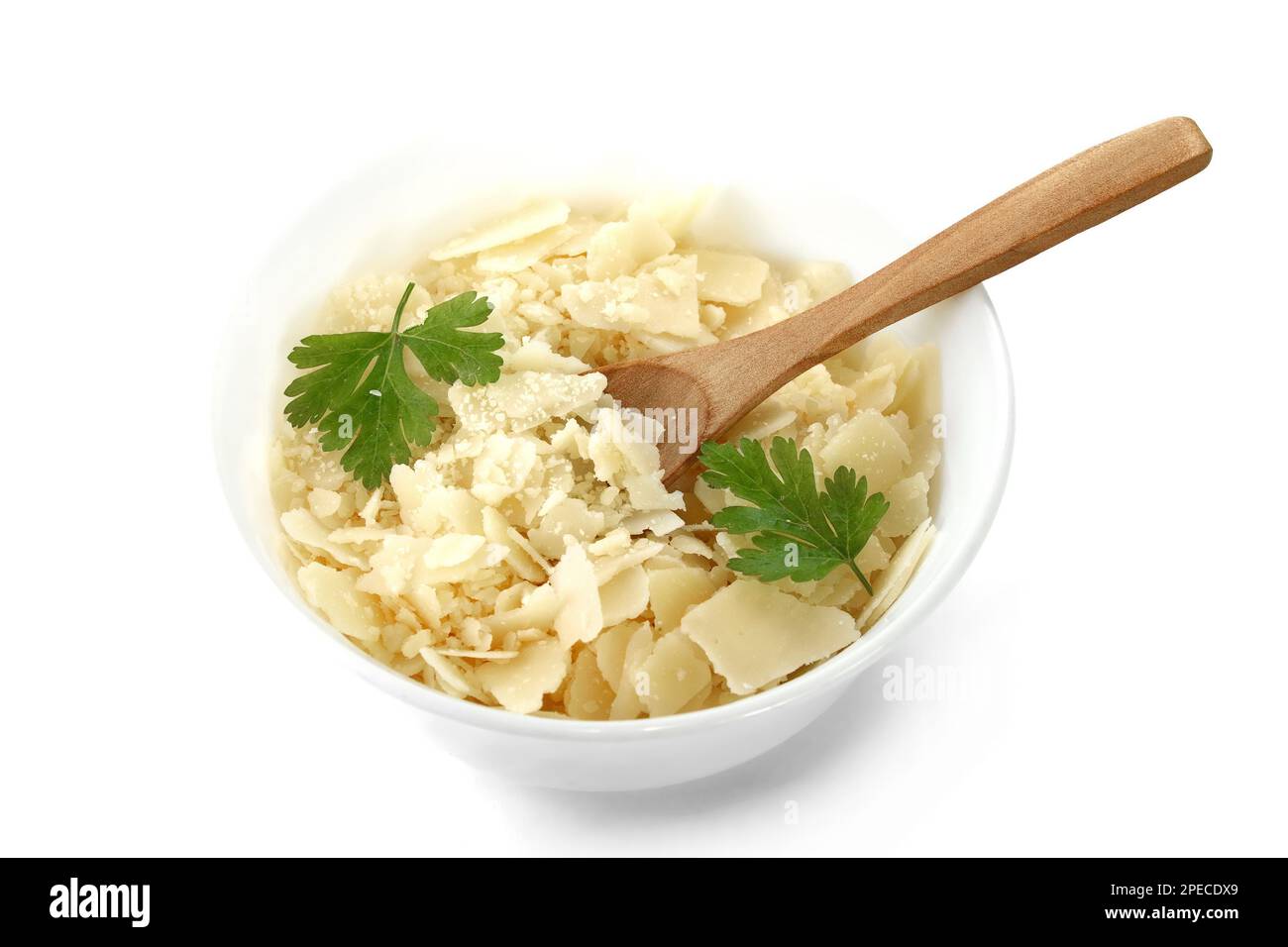 Parmesan cheese flakes in a bowl isolated on white background. Pile of ...