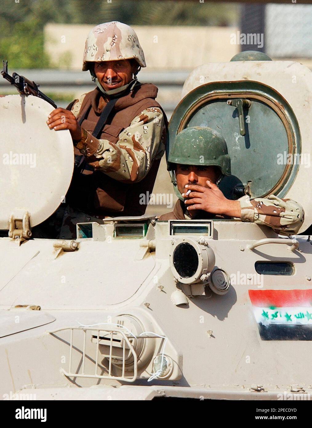 Two Iraqi soldiers patrol a highway in an armoured personnel carrier in ...