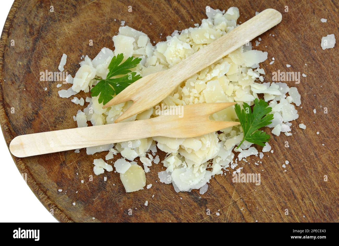 Parmesan cheese flakes on wooden board. Pile of parmesan cheese flakes ...