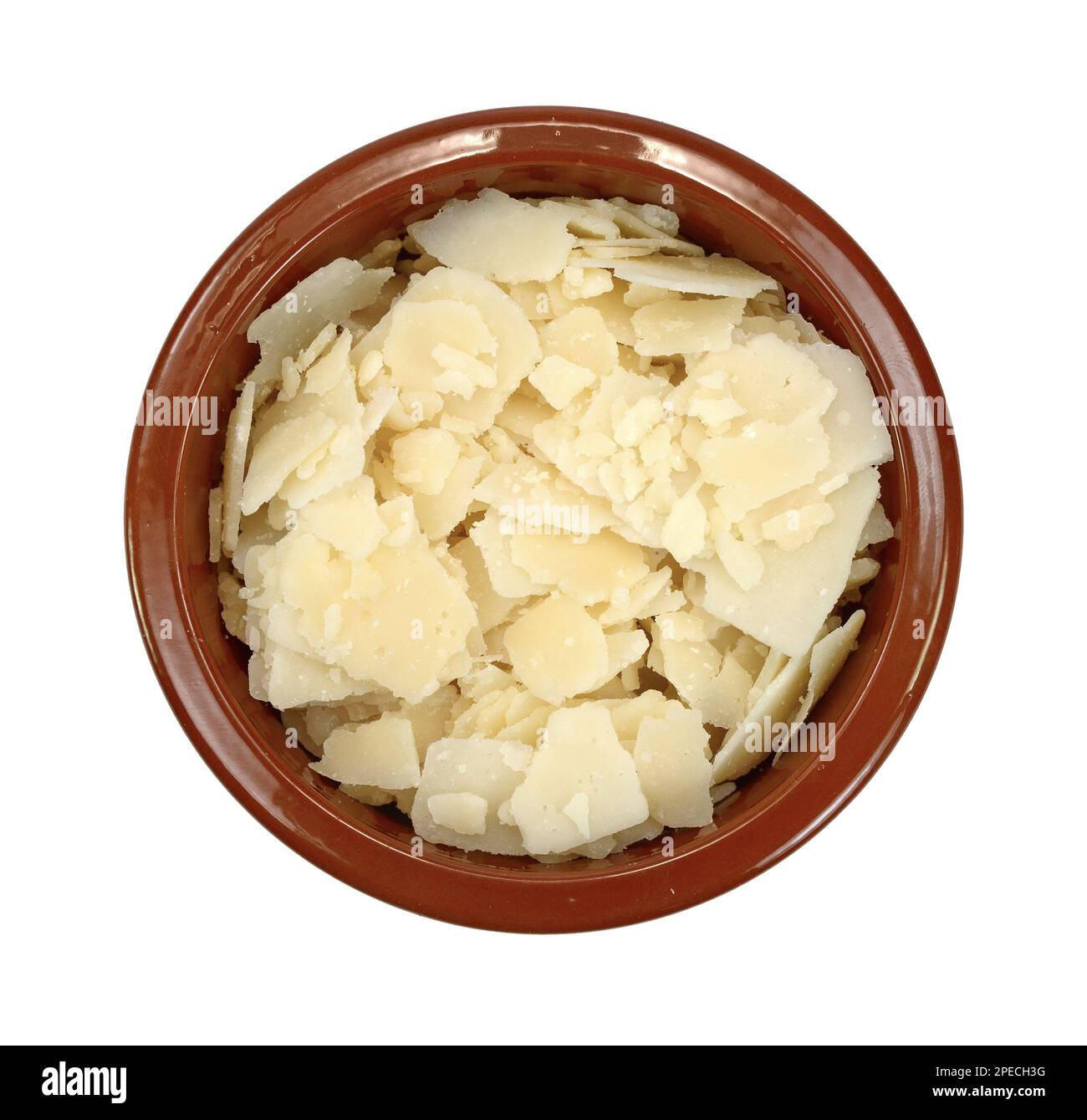 Parmesan cheese flakes in a bowl isolated on white background. Pile of ...