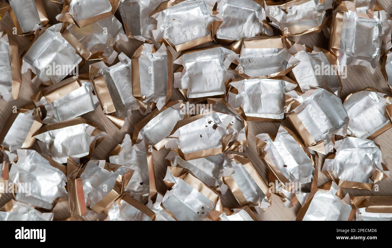Pile of empty silver-gold candy wrappers. Top view Stock Photo - Alamy