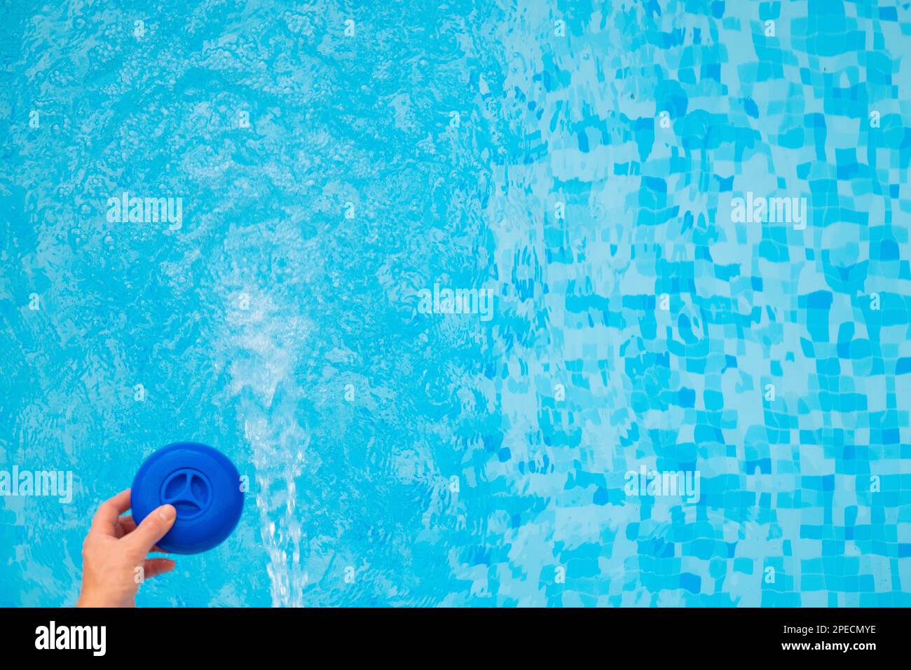 Pool water filtration.hand throws a cleaning filter with chlorine ...