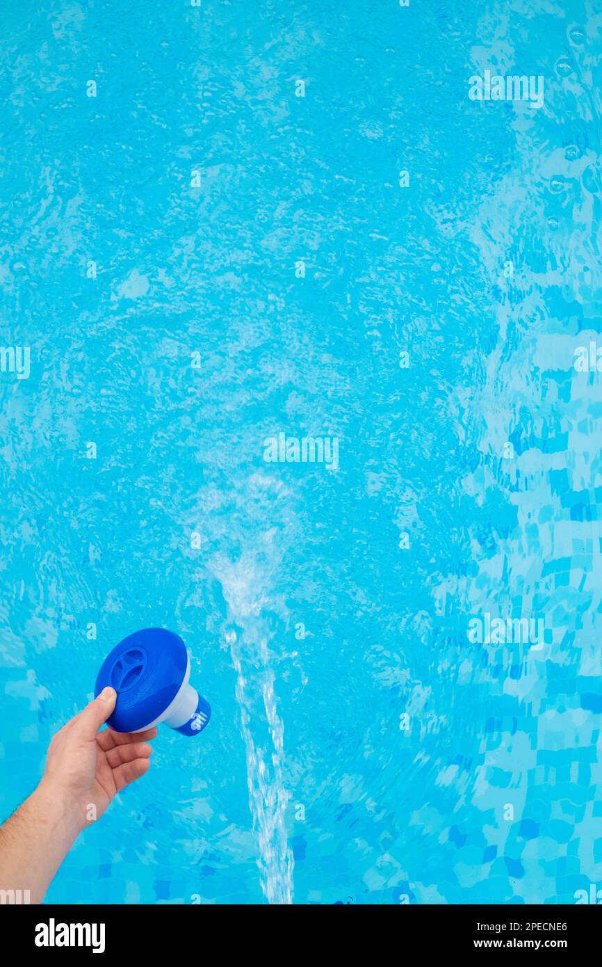 pool Filter. hand throws a cleaning filter in blue water of the pool ...