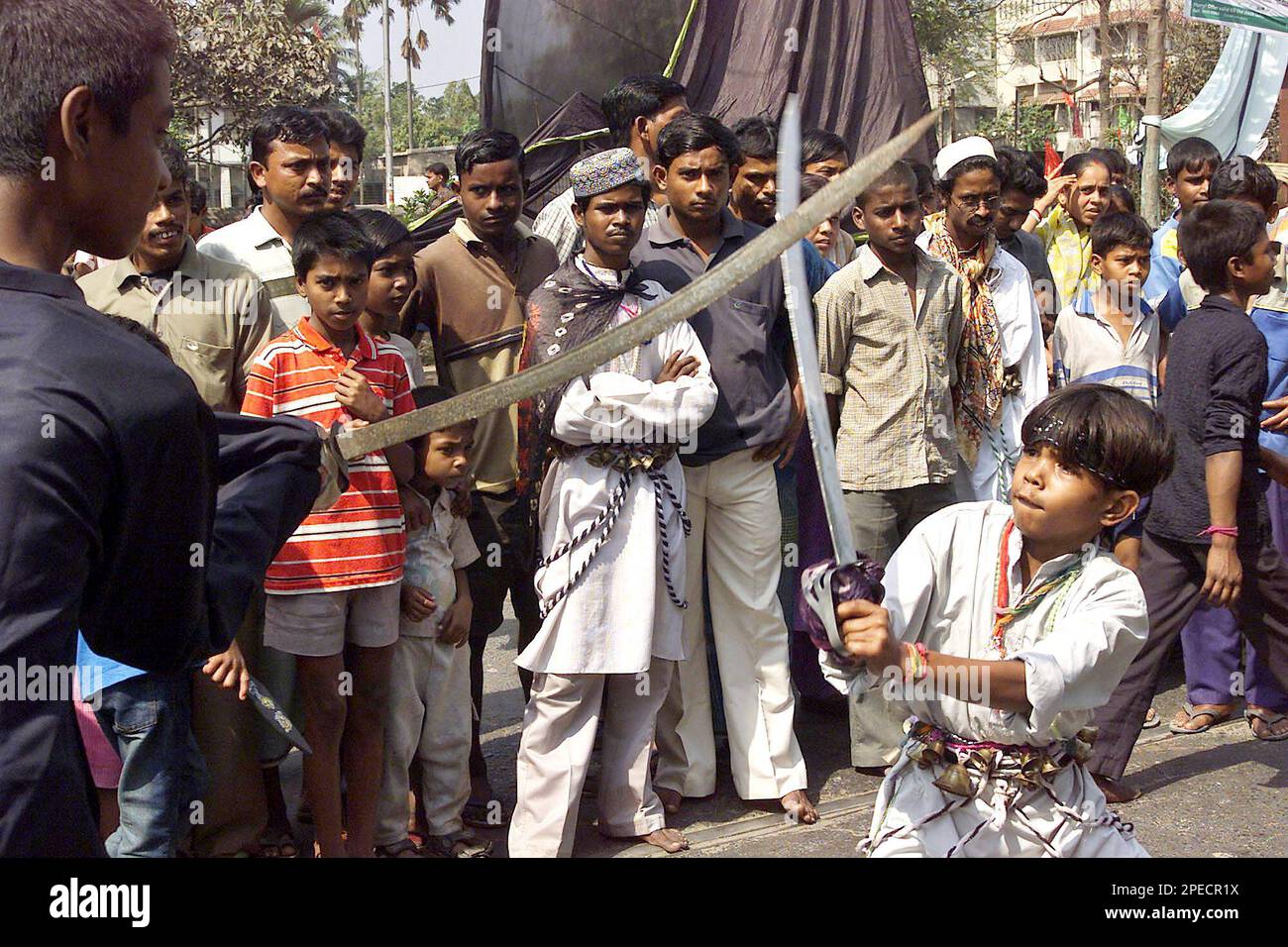 Muslim boys engage themselves in a mock sword fight during Muharram ...