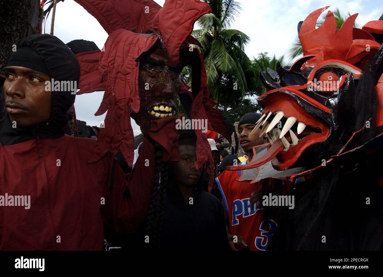 A man dressed as a devil carries a mask during the devil festival in ...