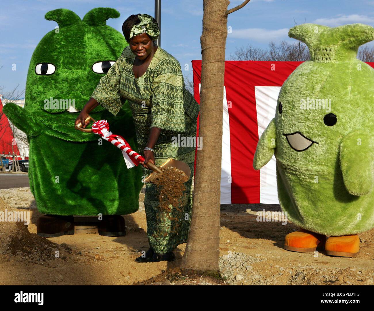 Kenyan Nobel Peace Prize laureate Wangari Maathai, center, uses a scoop ...