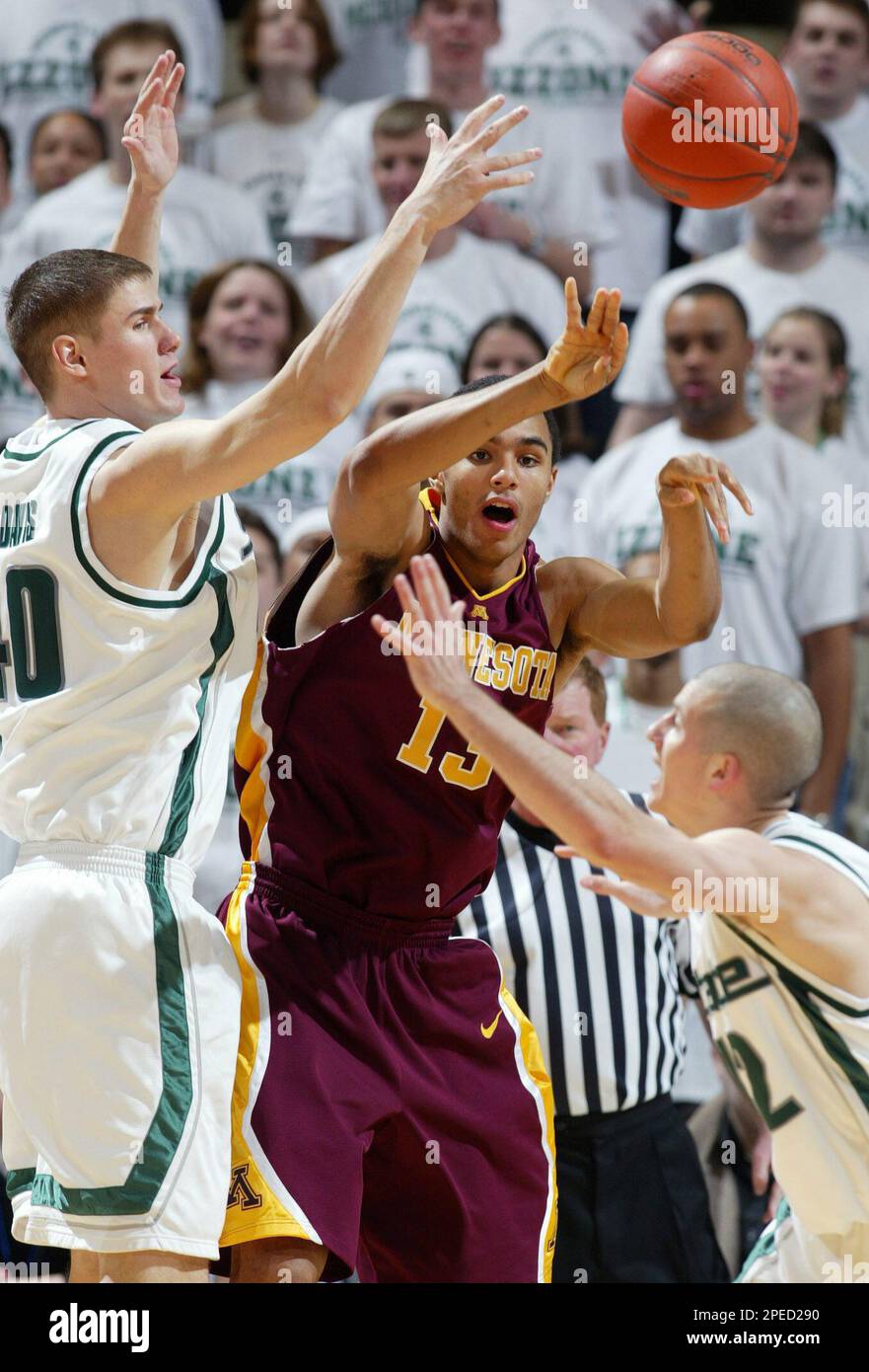 Minnesota's Dan Coleman, center, passes against pressure from Michigan ...