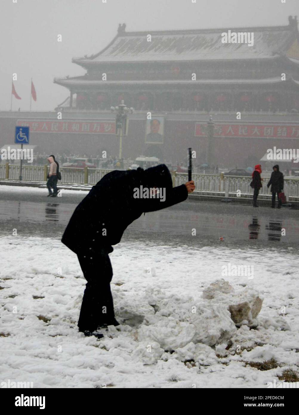 A policeman destroys a snowman in Beijing's Tiananmen Square Tuesday ...