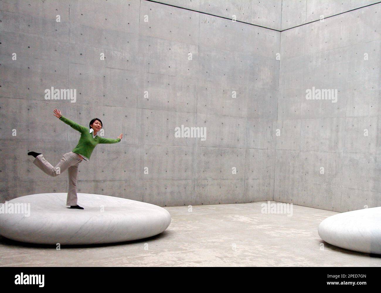 Visitor Chang-Ran Kim poses on one of Yasuda Kan's stone sculptures ...
