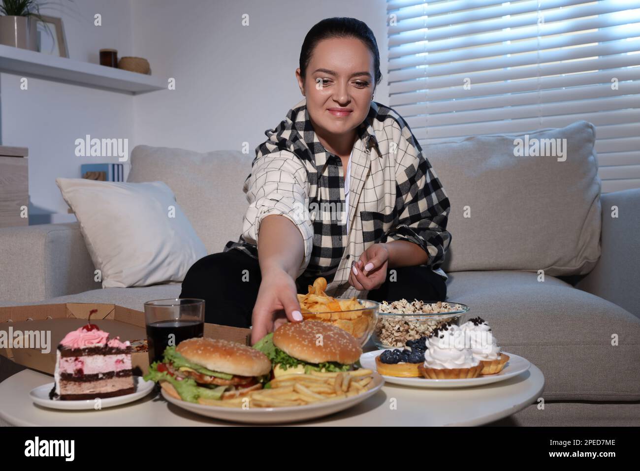 Happy overweight woman with unhealthy food at home Stock Photo - Alamy