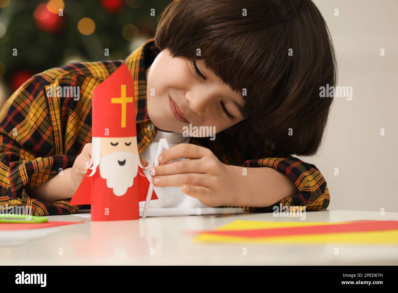 Cute little boy making paper Saint Nicholas toy at home Stock Photo - Alamy