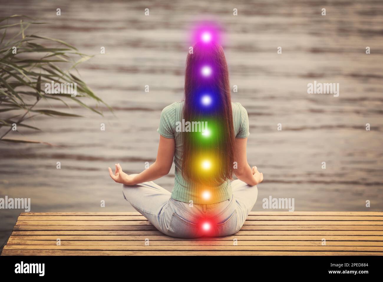 Teenage girl meditating near river, back view. Scheme of seven chakras ...