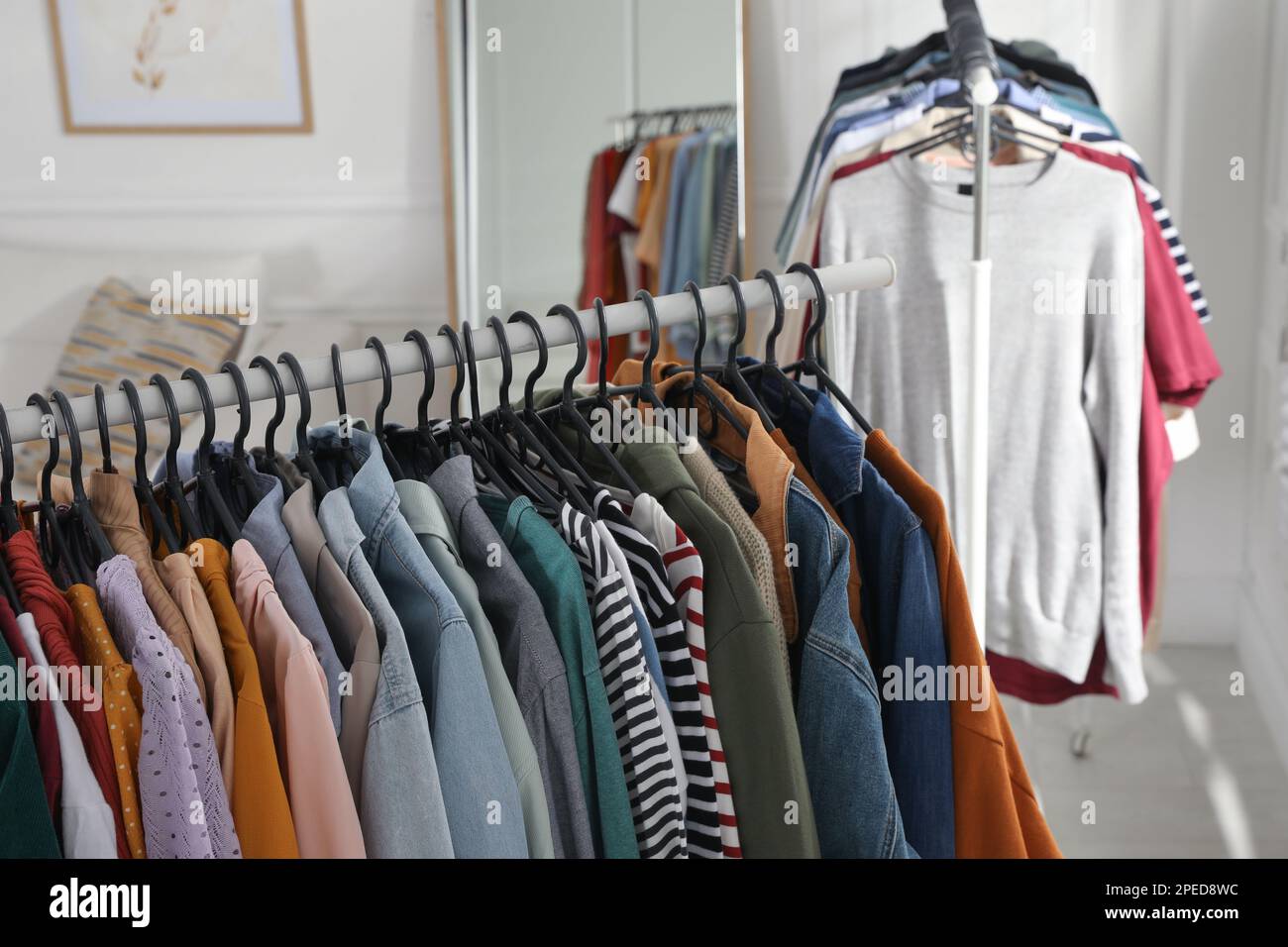 Racks with stylish clothes indoors. Fast fashion Stock Photo - Alamy