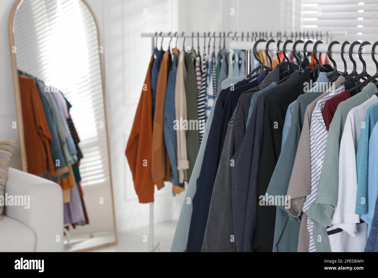 Racks with stylish clothes indoors. Fast fashion Stock Photo - Alamy