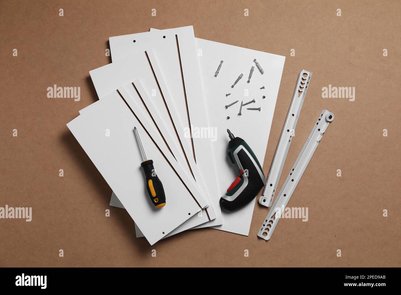 Furniture parts and tools for self-assembly on brown background, flat ...