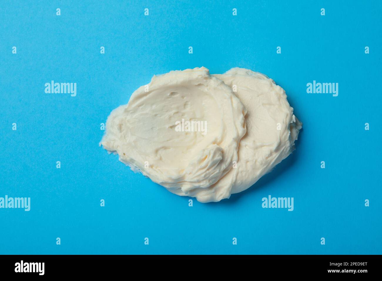 Smear of delicious cream cheese on light blue background, top view ...