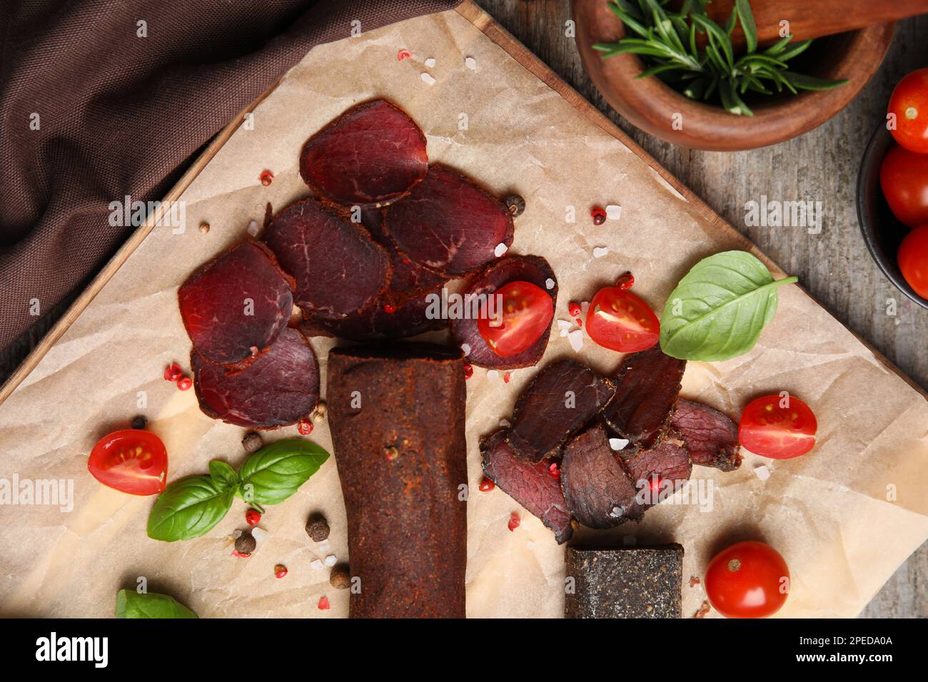 Delicious dry-cured beef basturma with basil, tomatoes and spices on ...