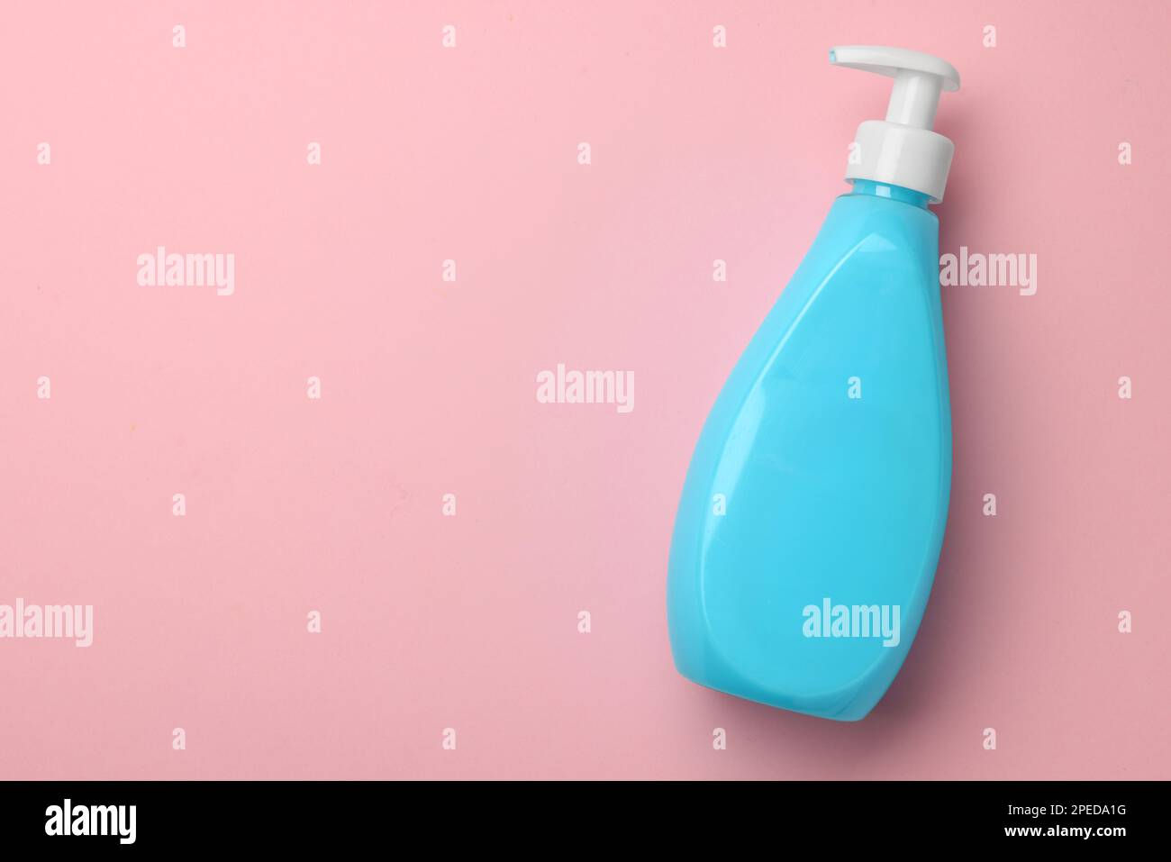 Bottle of liquid soap on pink background, top view. Space for text ...