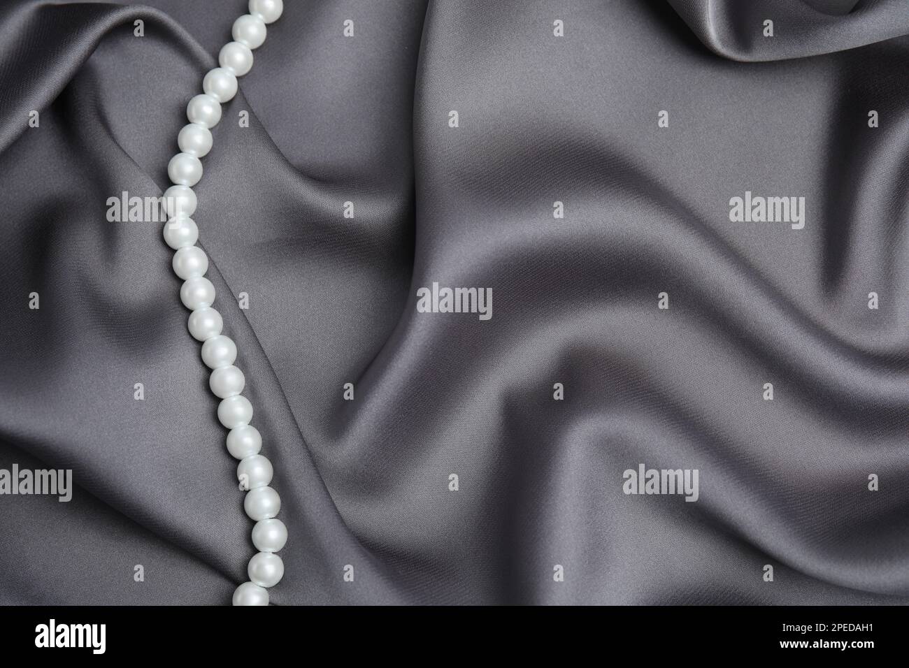 Beautiful pearls on grey silk, top view. Space for text Stock Photo - Alamy