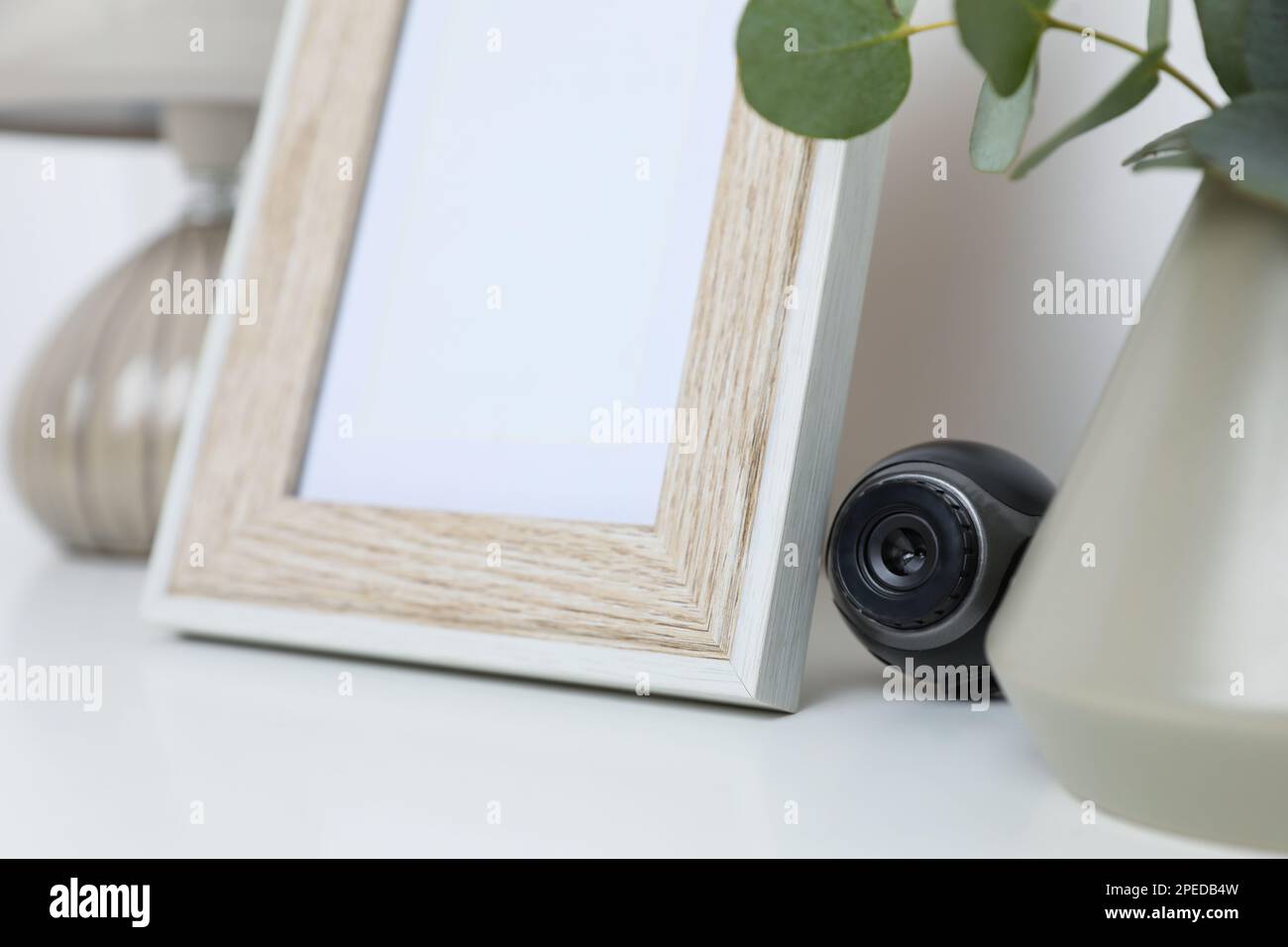 Small camera hidden among home stuff on white table Stock Photo - Alamy