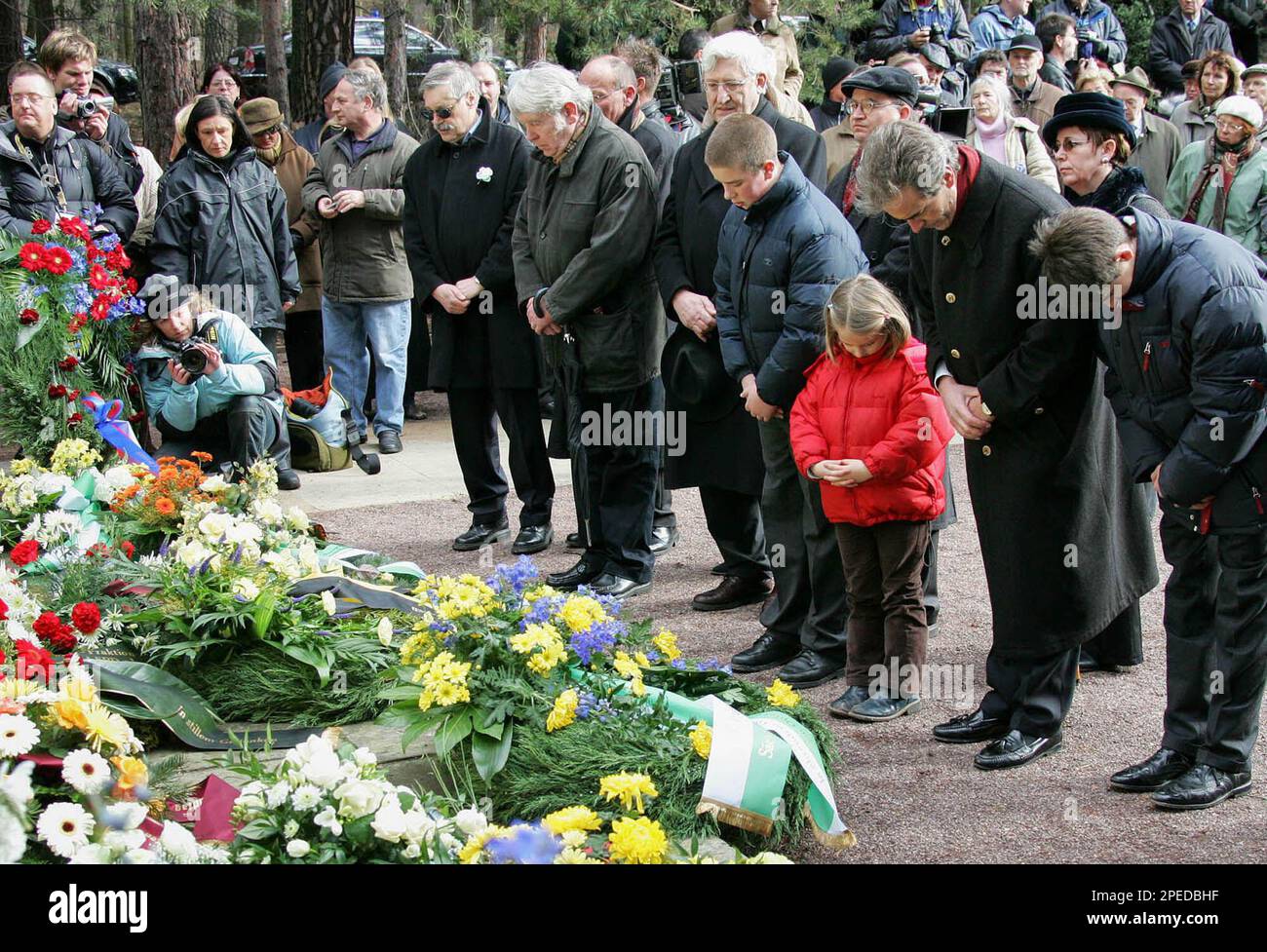 People bow in front of the commemoration wall at a cemetery in Dresden ...
