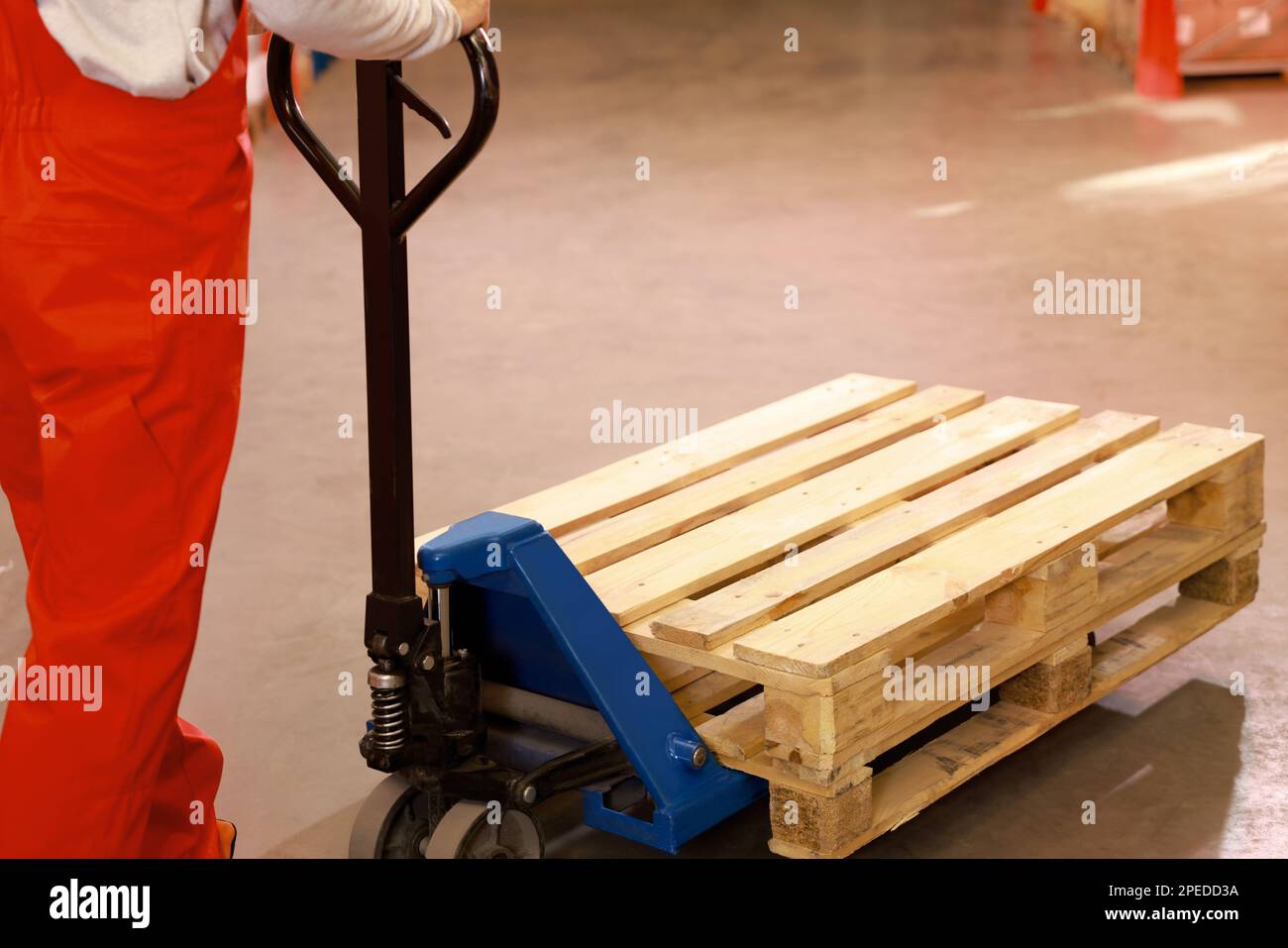 Worker moving wooden pallets with manual forklift in warehouse, closeup ...