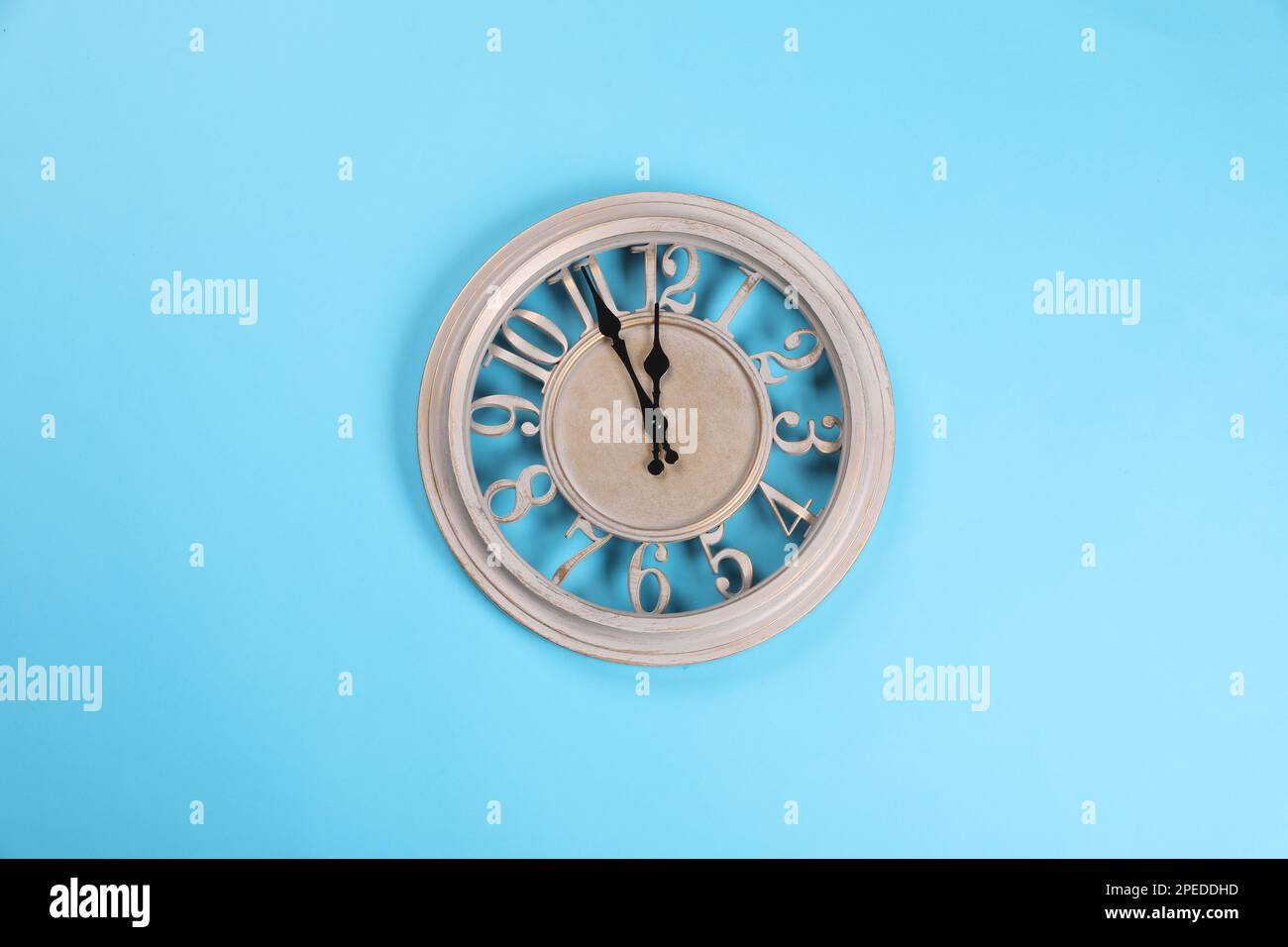 Stylish wall clock showing five minutes until midnight on turquoise ...