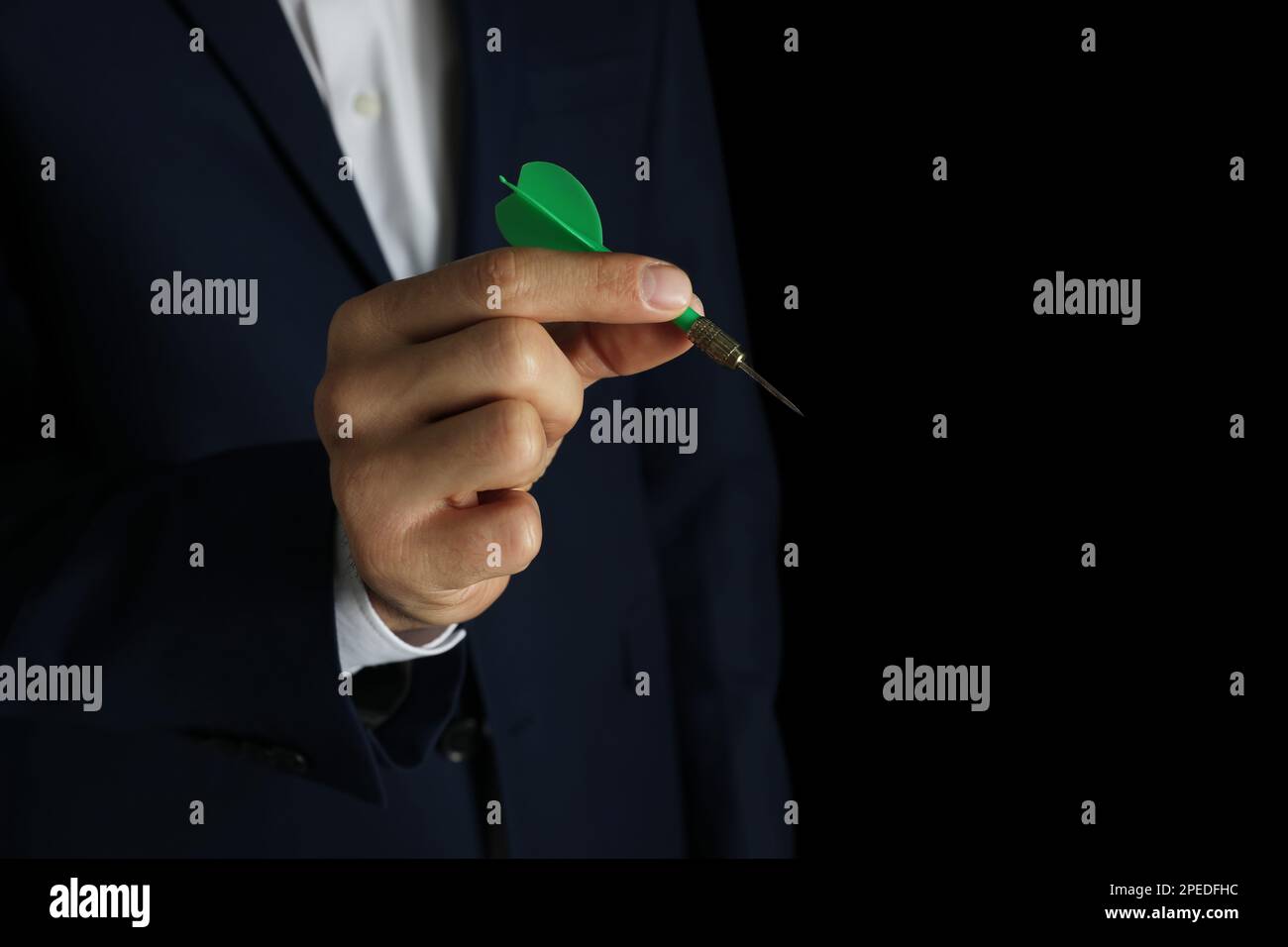 Man holding green dart on black background, closeup Stock Photo - Alamy