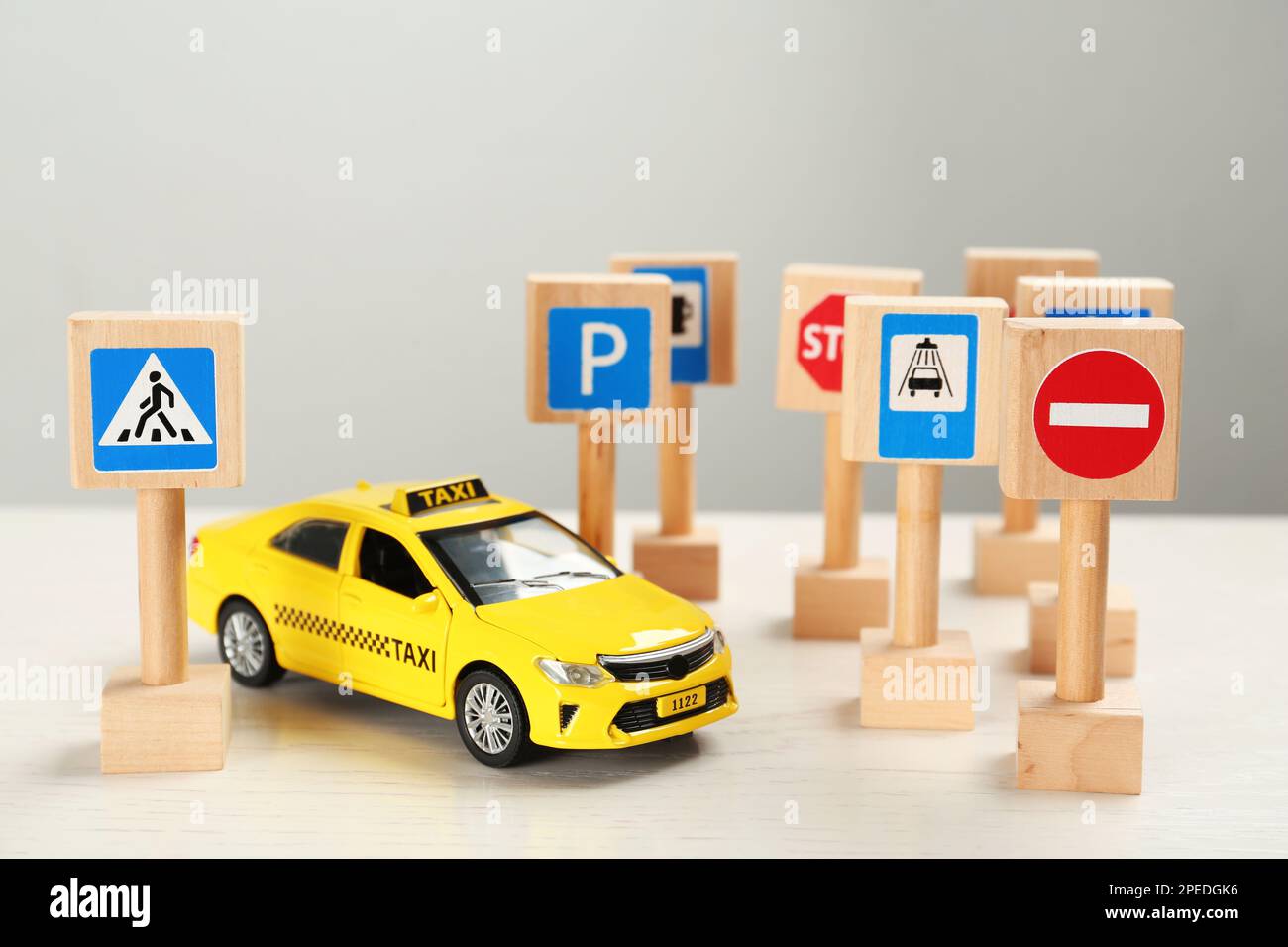 Miniature road signs and car on white table. Driving school Stock Photo ...