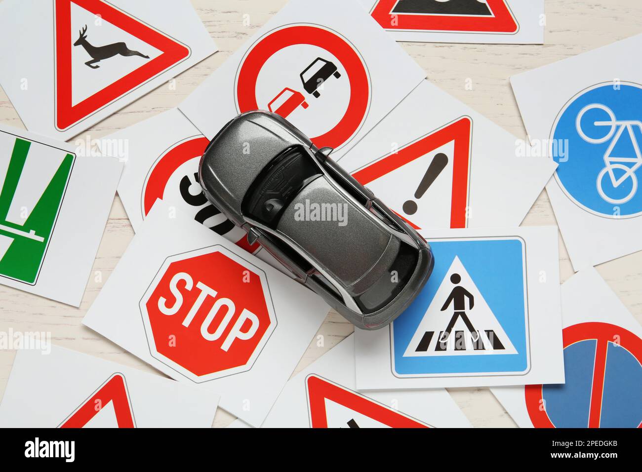 Cards with different road signs and toy car on white wooden table, flat ...