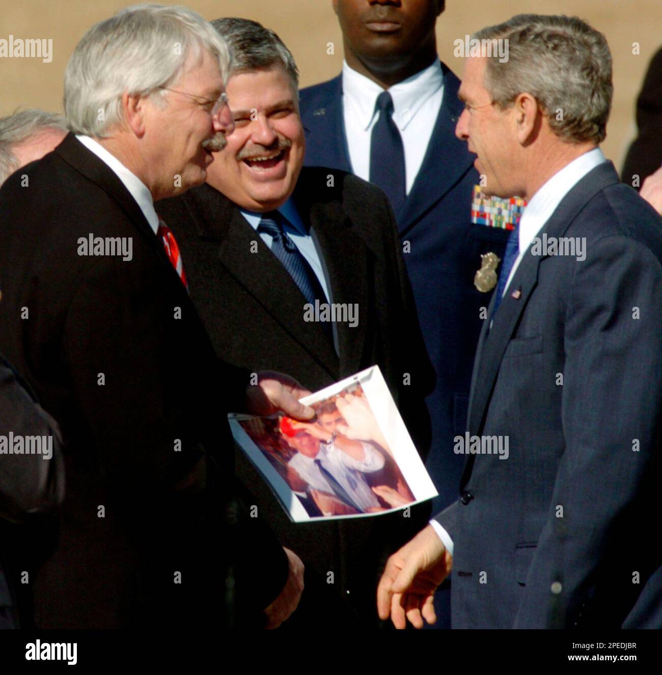 President Bush, right, is shown a photograph of himself as he is ...