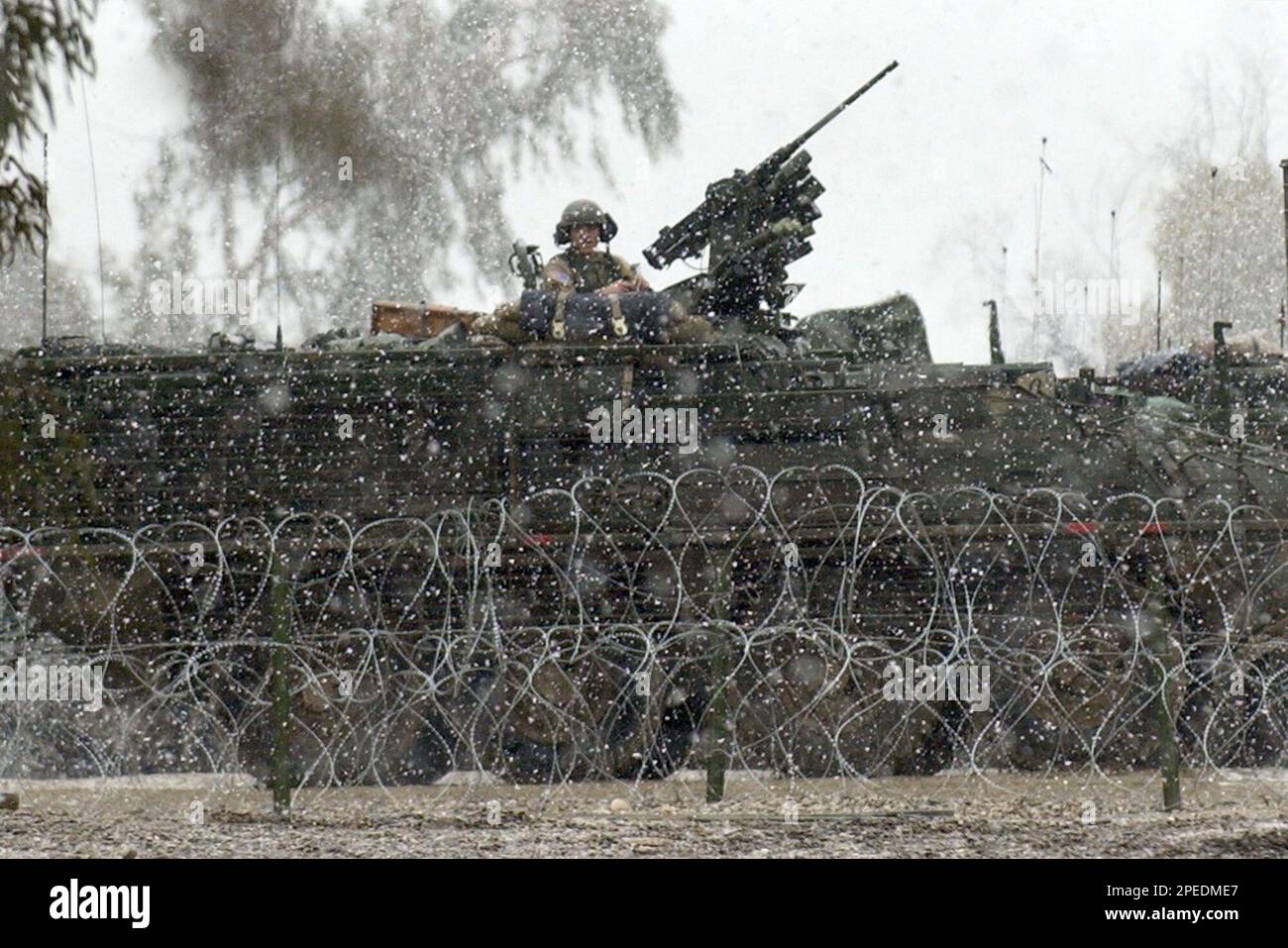 A U.S. Army Stryker combat vehicle drives through falling snow at ...