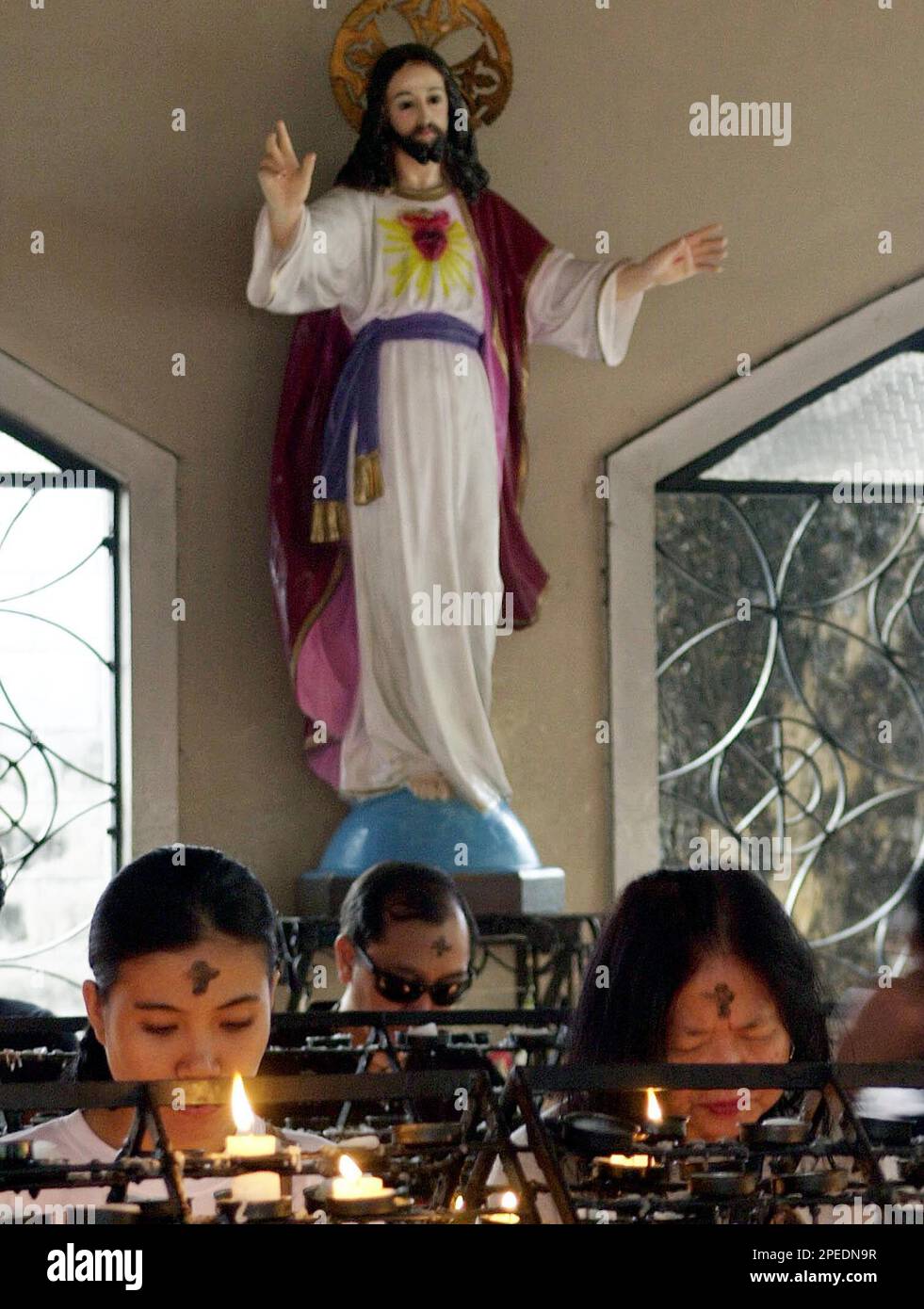 Catholic devotees with cross marks from ashes on their forehead pray ...